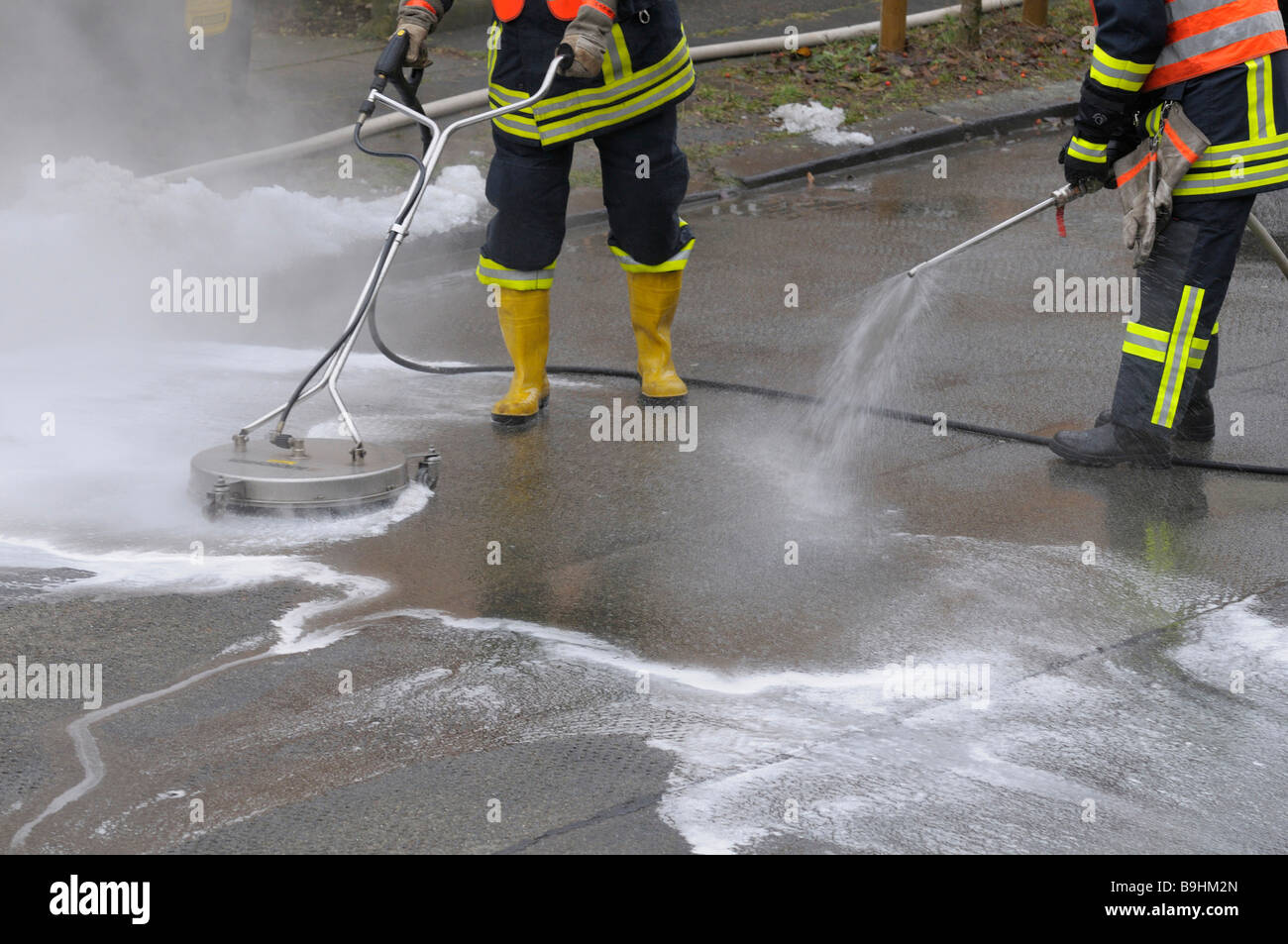 Fire brigade in action, neutralising leaked brake fluid with cleaning ...