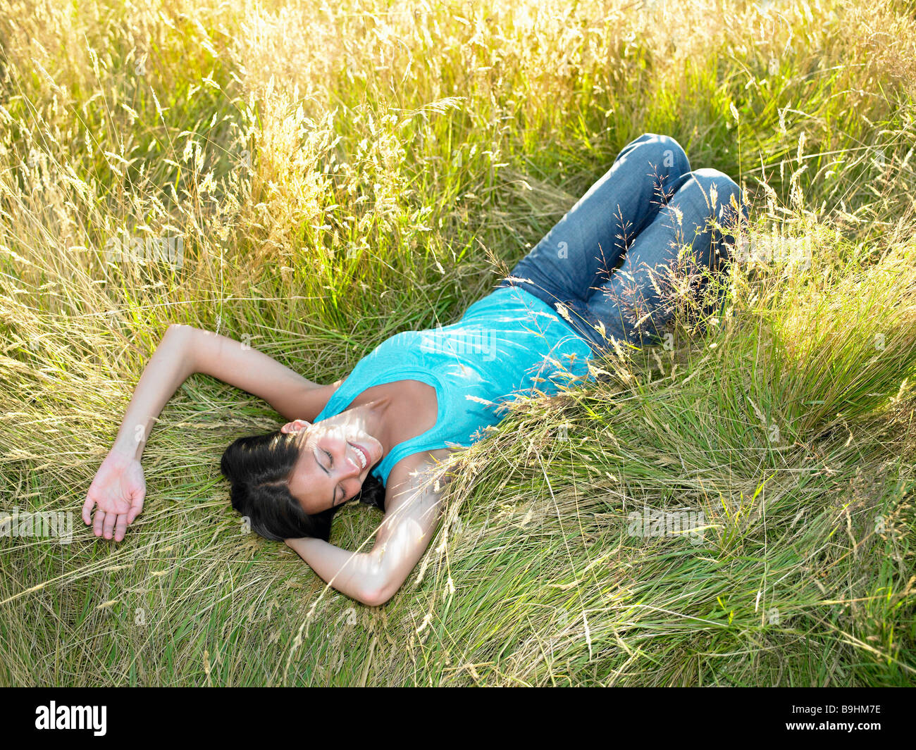 Woman laying down in a field Stock Photo - Alamy