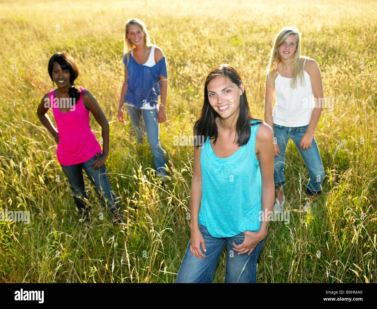 Women standing in a field, smiling Stock Photo - Alamy