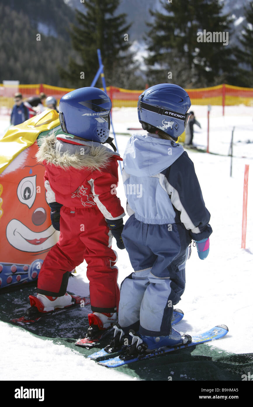 Children ski course ski-track stands back view Departure beginners glasses vacation figure ...