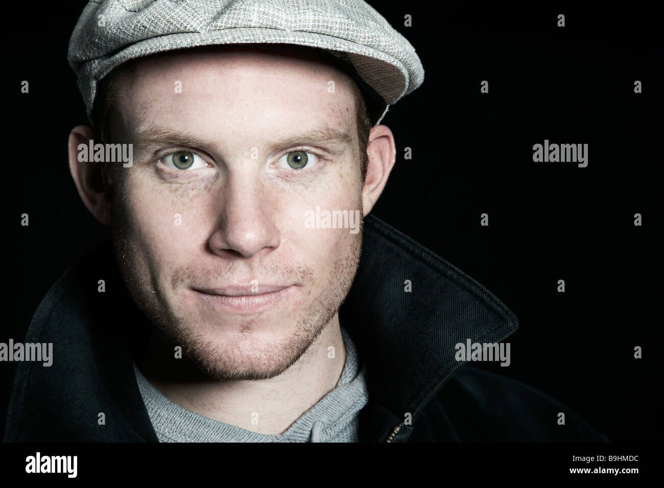 Portrait of a young man wearing a peaked cap looking into camera Stock ...