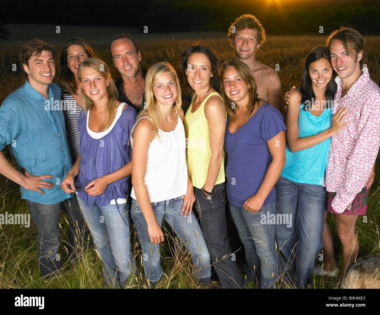 Group of friends in a field, smiling Stock Photo - Alamy