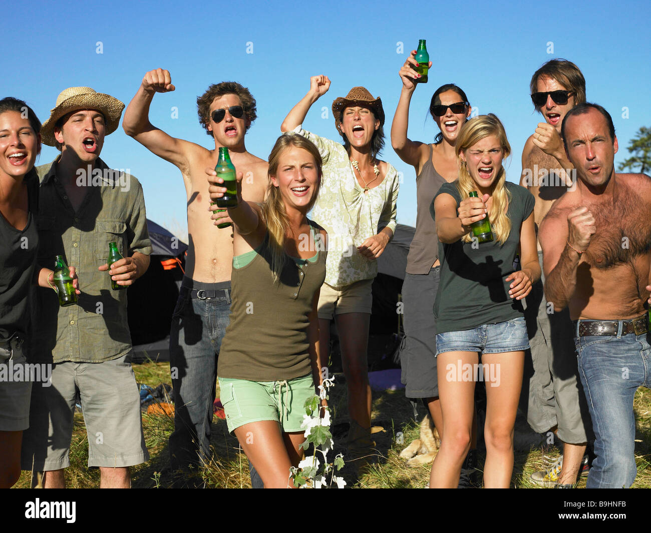 People in a field, raising their beer Stock Photo - Alamy