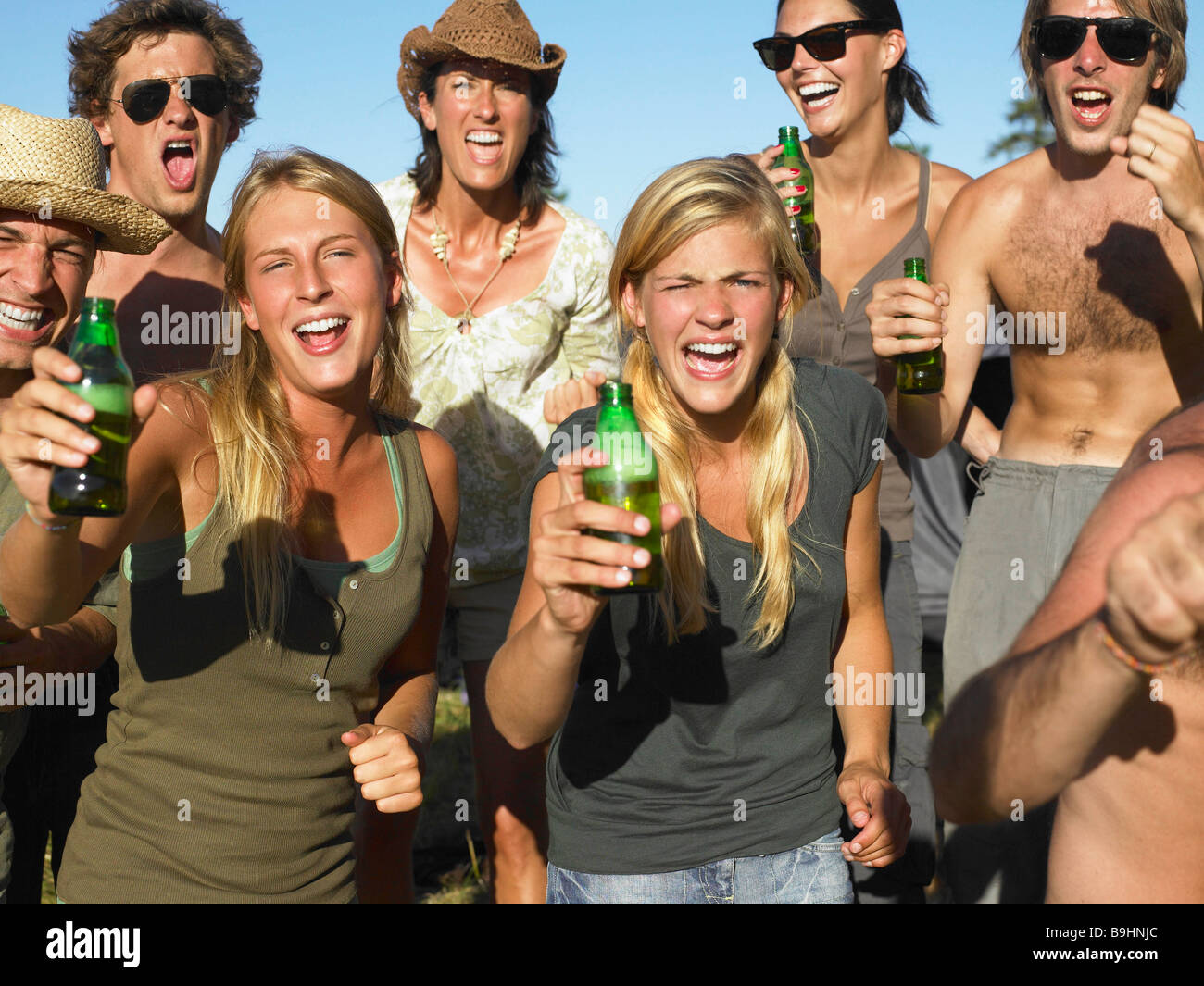 People in a field, raising their beer Stock Photo - Alamy