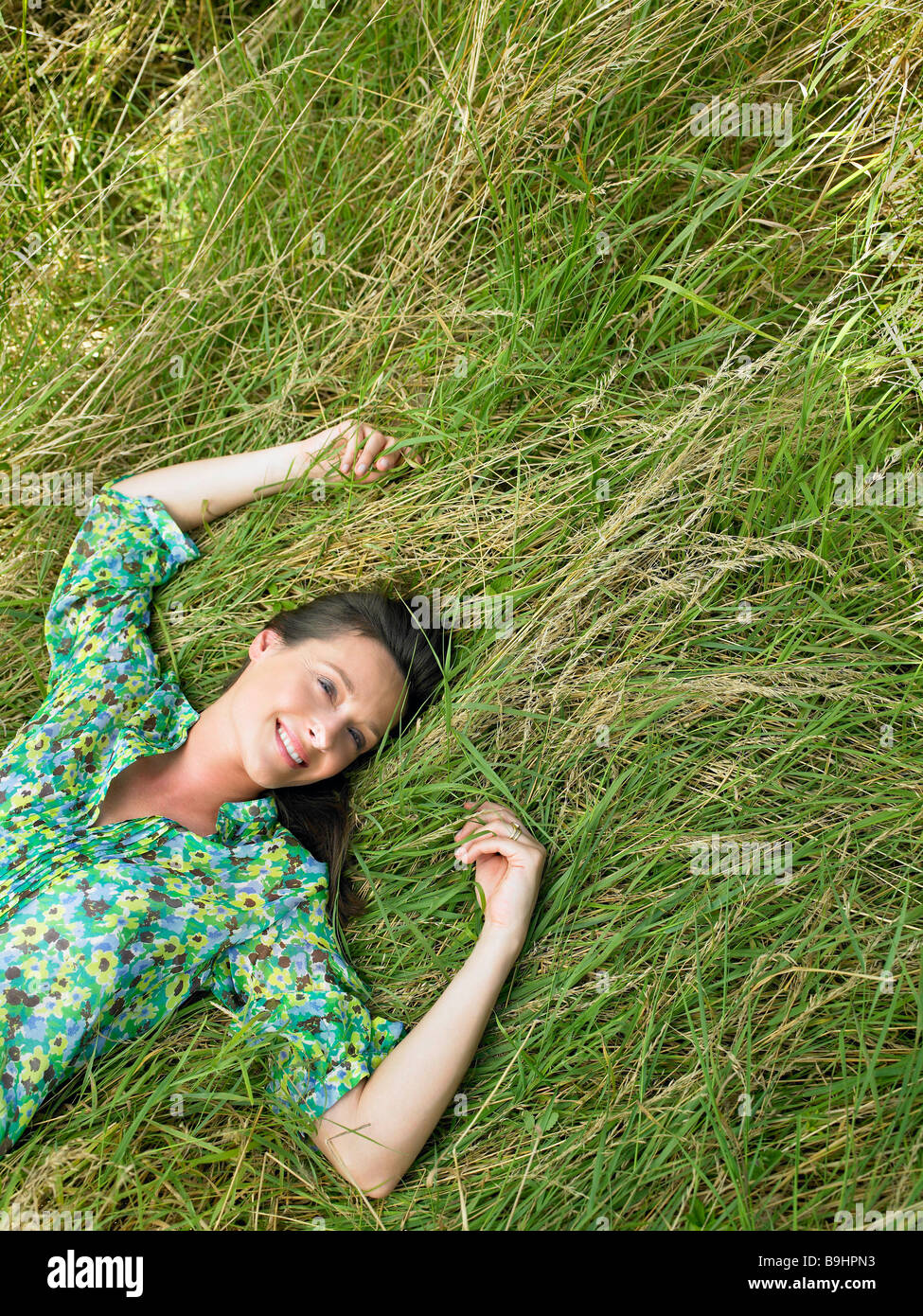 Woman laying down in a field Stock Photo - Alamy