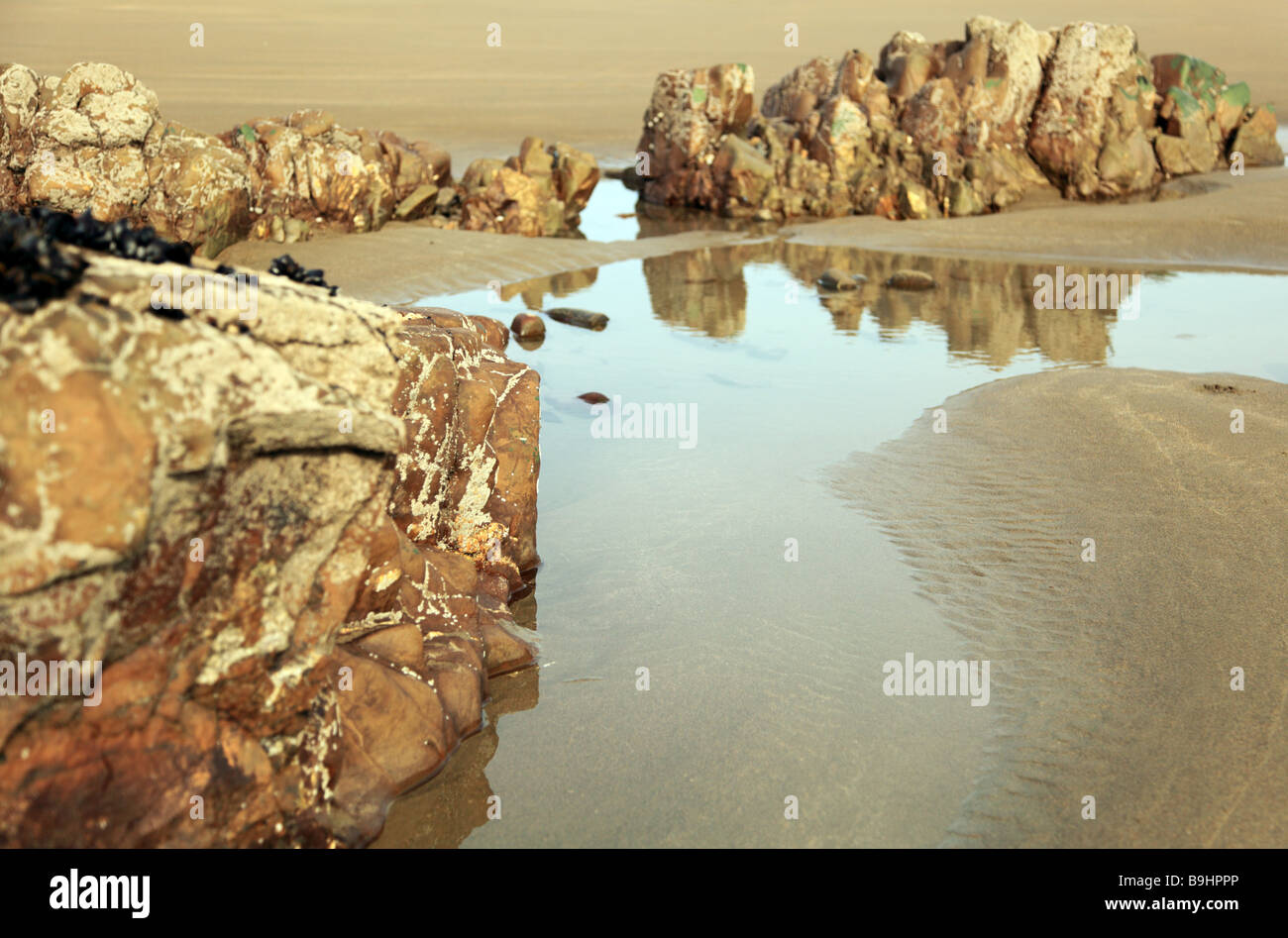 A rock pool with large boulders and reflections Stock Photo - Alamy