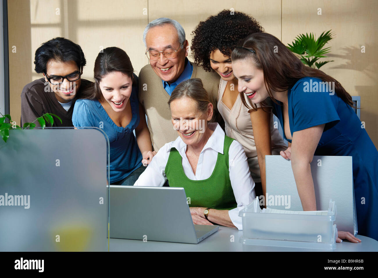 Group of people looking at laptop Stock Photo - Alamy