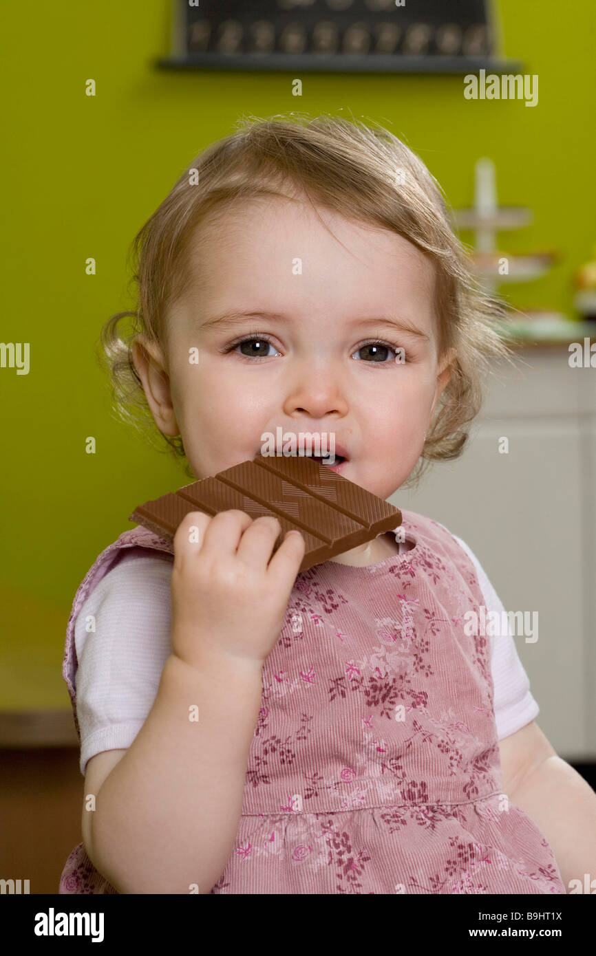 Young girl biting into chocolate bar Stock Photo - Alamy