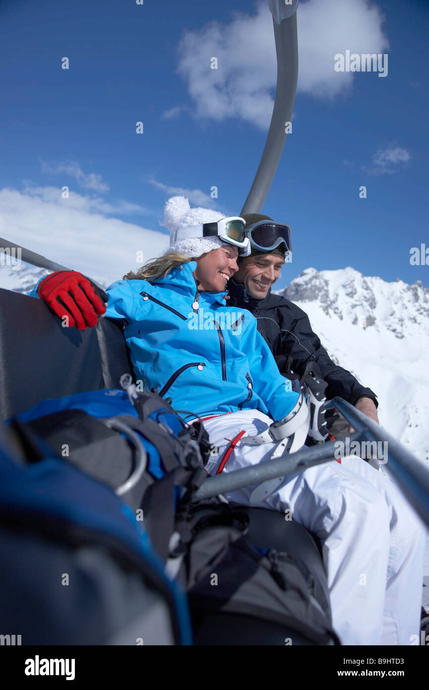 Couple sitting close in chair lift Stock Photo - Alamy
