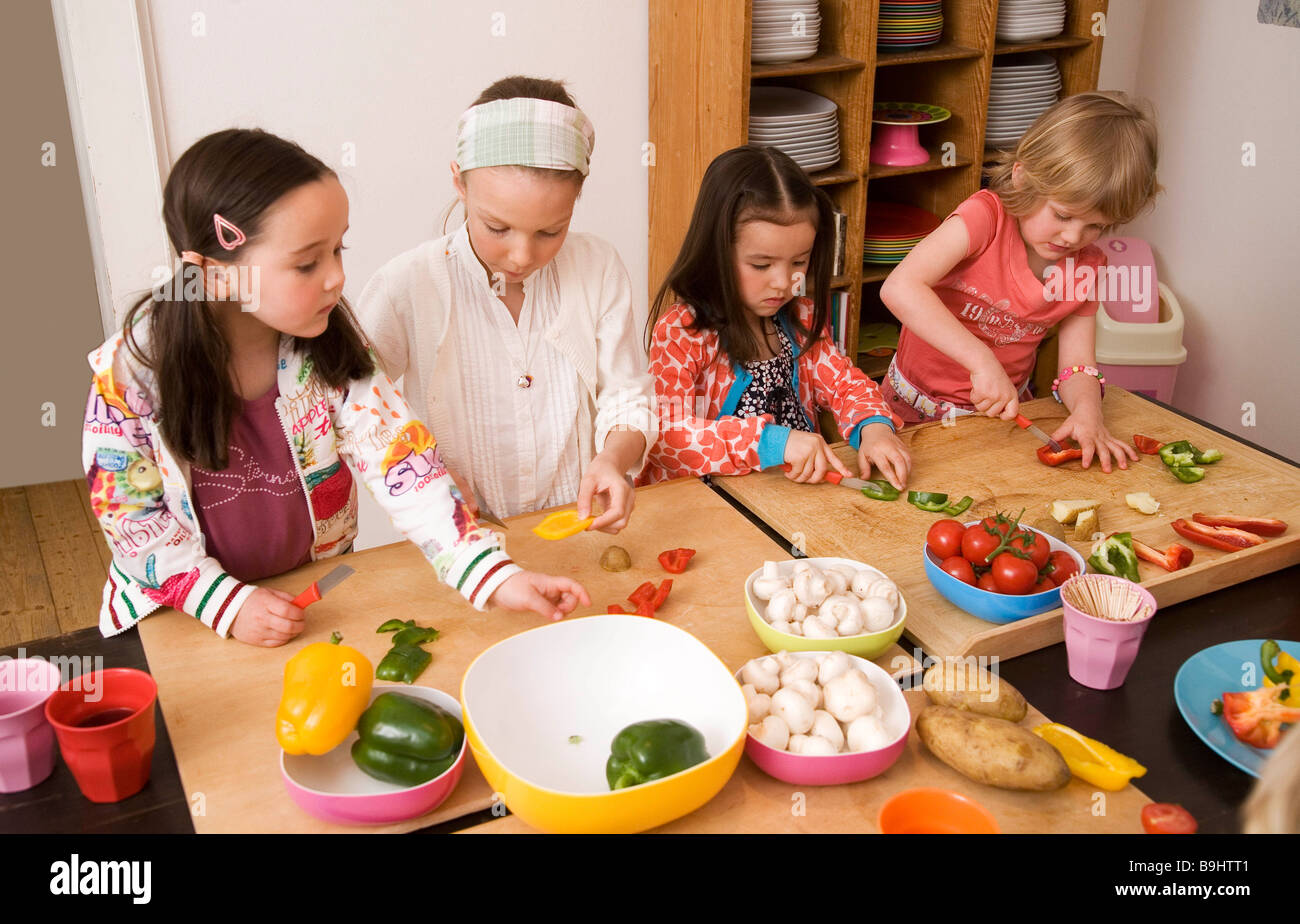 Four girls cutting vegetables Stock Photo - Alamy