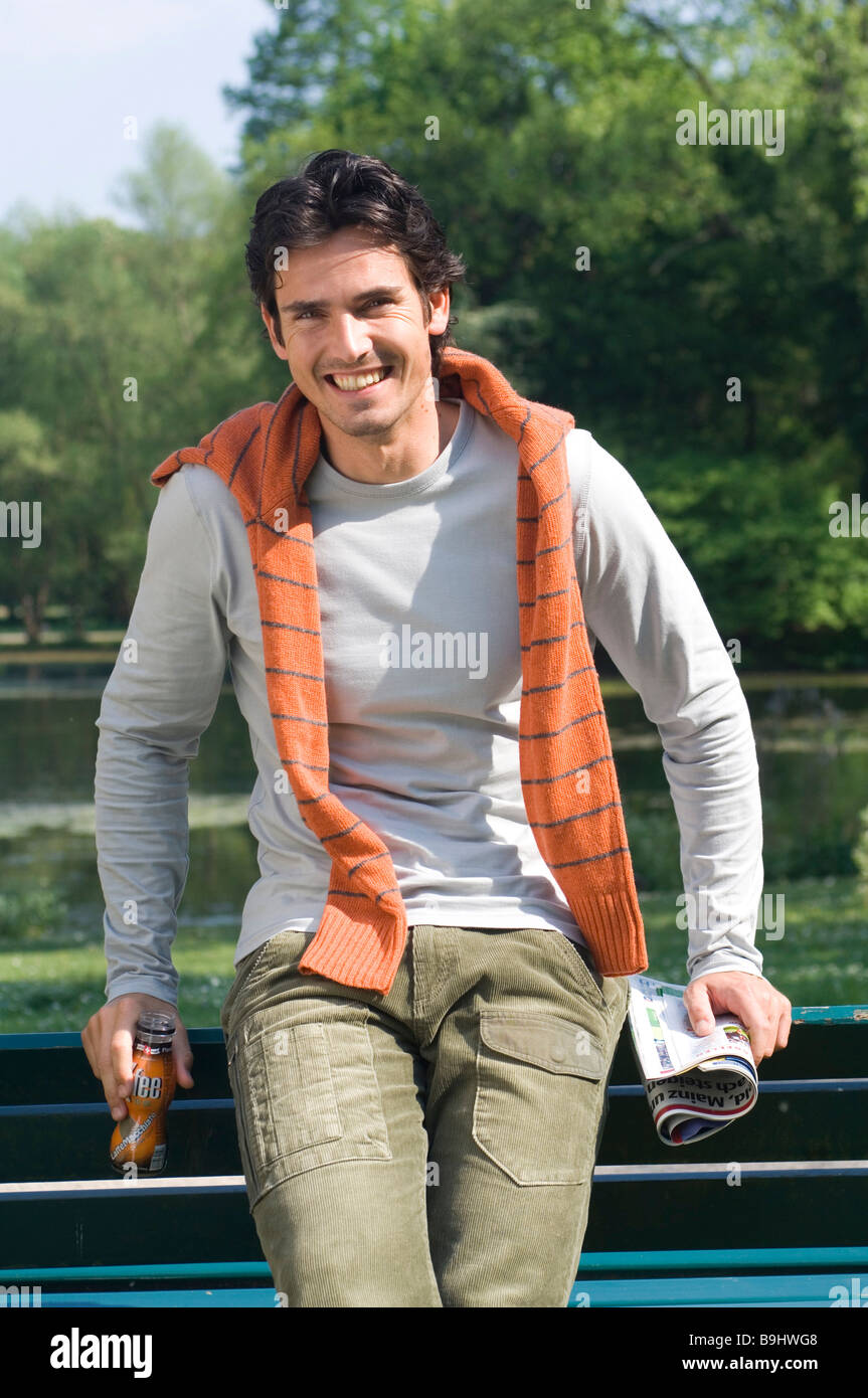 Man leaning against a park bench Stock Photo - Alamy