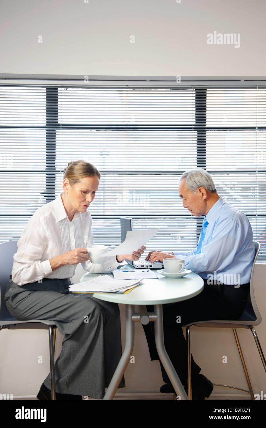 Senior co-workers sharing table Stock Photo - Alamy