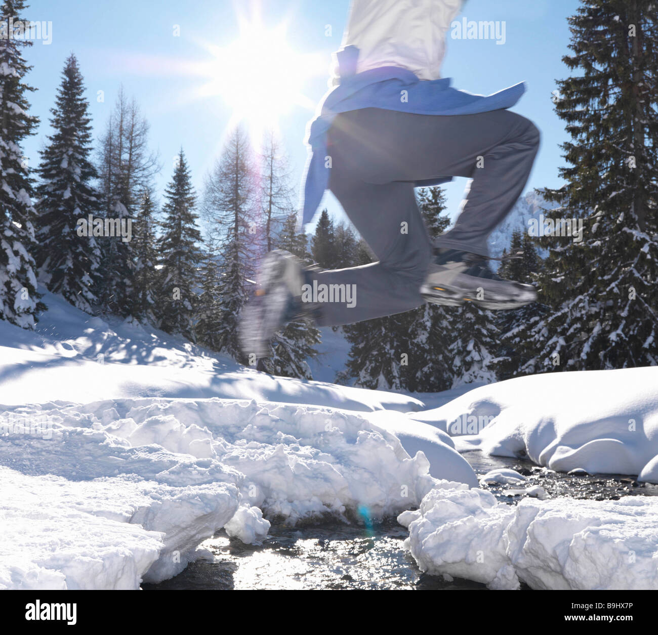 Man jumping across stream Stock Photo - Alamy