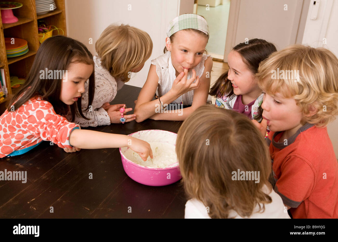 Girls and boys tasting dish Stock Photo - Alamy