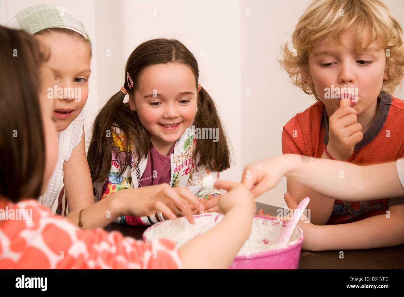 Girls and boys tasting dish Stock Photo - Alamy