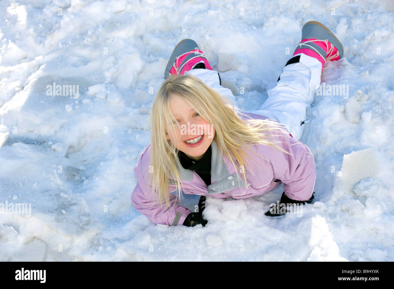 Girl rolling in snow Stock Photo - Alamy