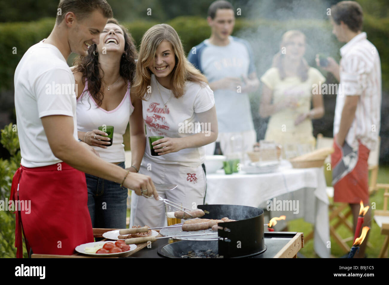 Group of young people having a barbecue in the garden Stock Photo - Alamy