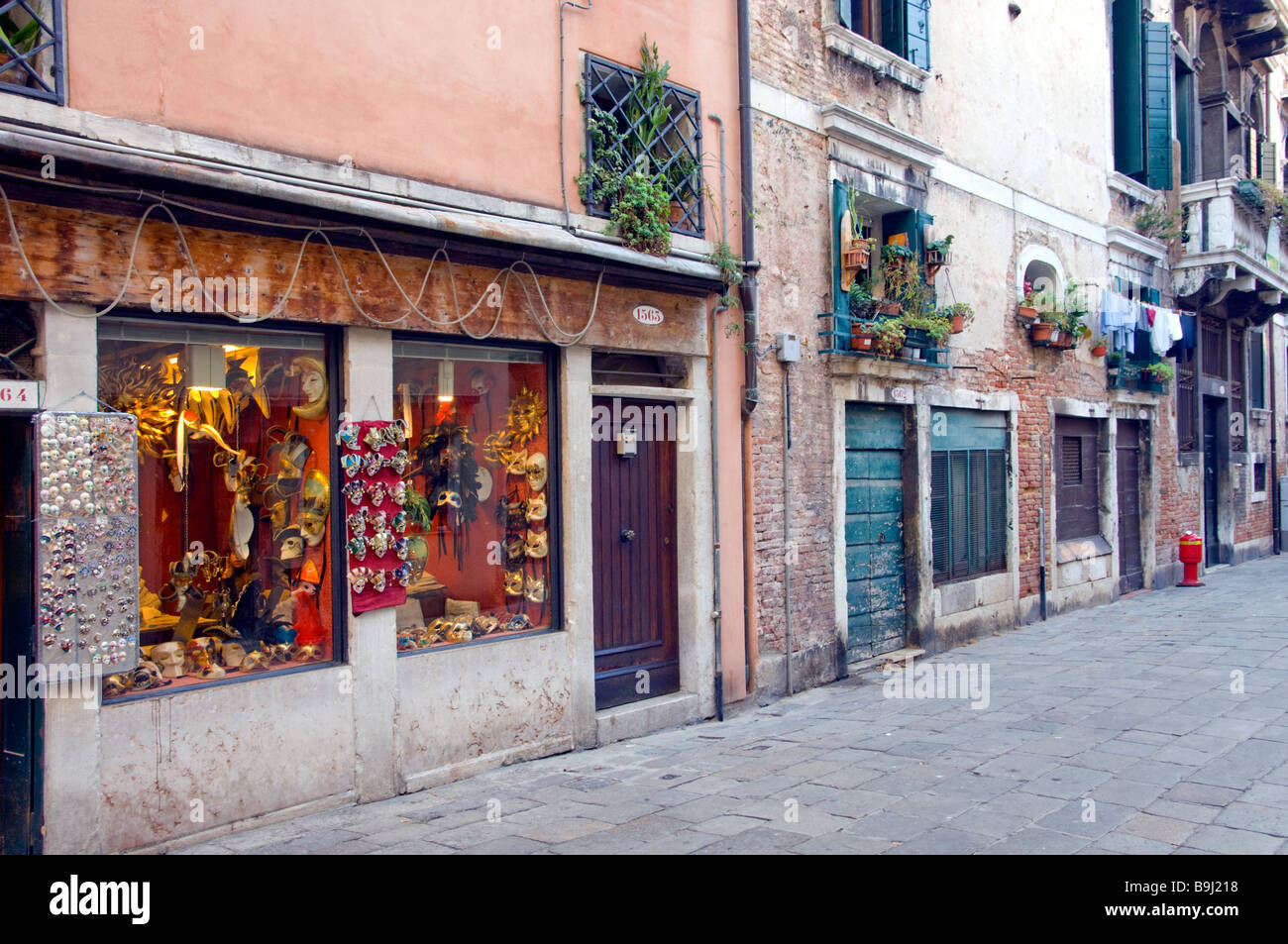 A canal side street with shops and window boxes in Venice, Italy ...