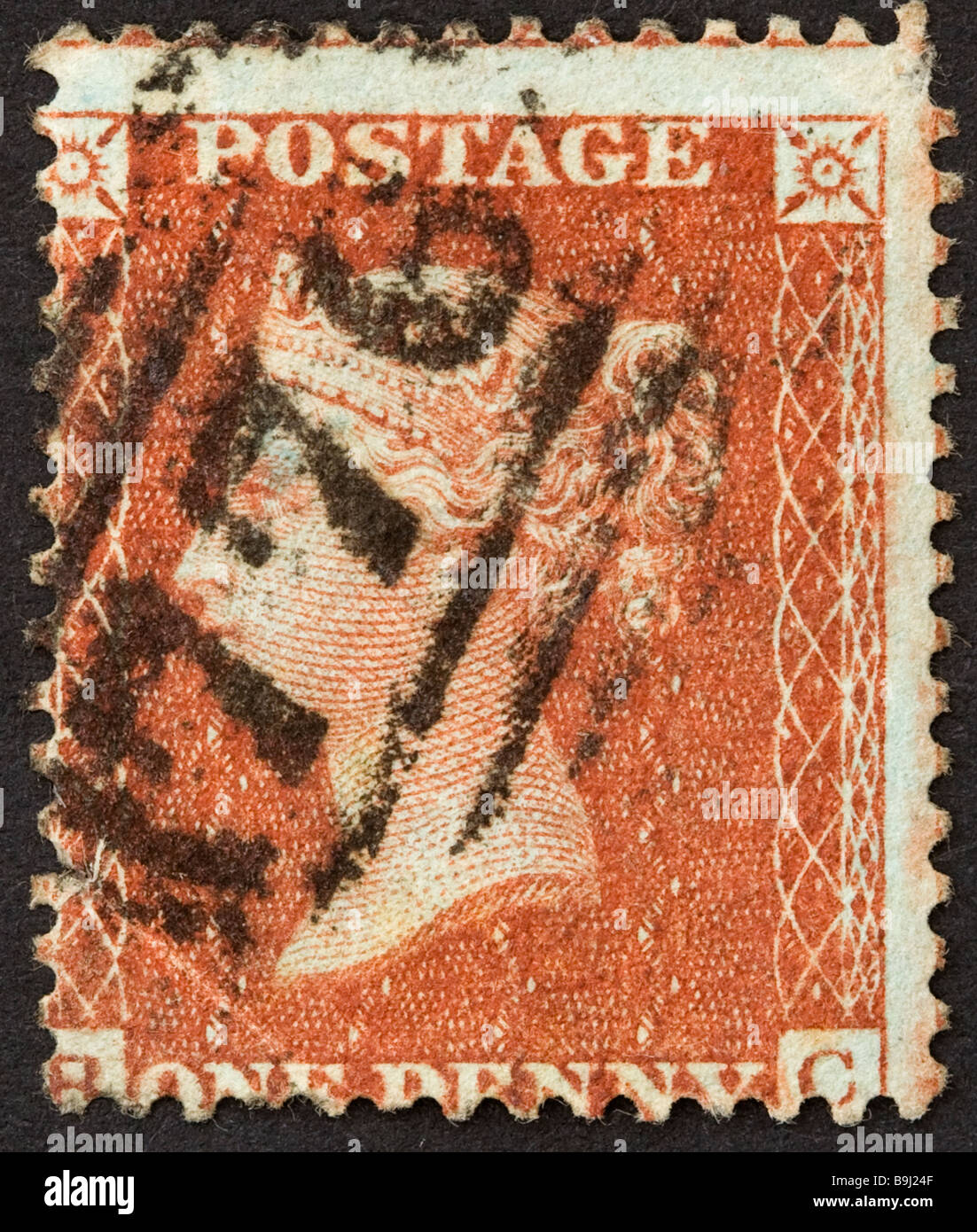 Macro 1d red Victorian British Postal stamp on black background. Used ...