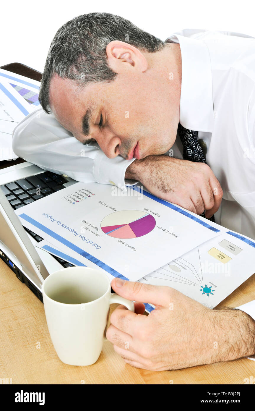 Tired businessman asleep at his desk isolated on white background Stock ...