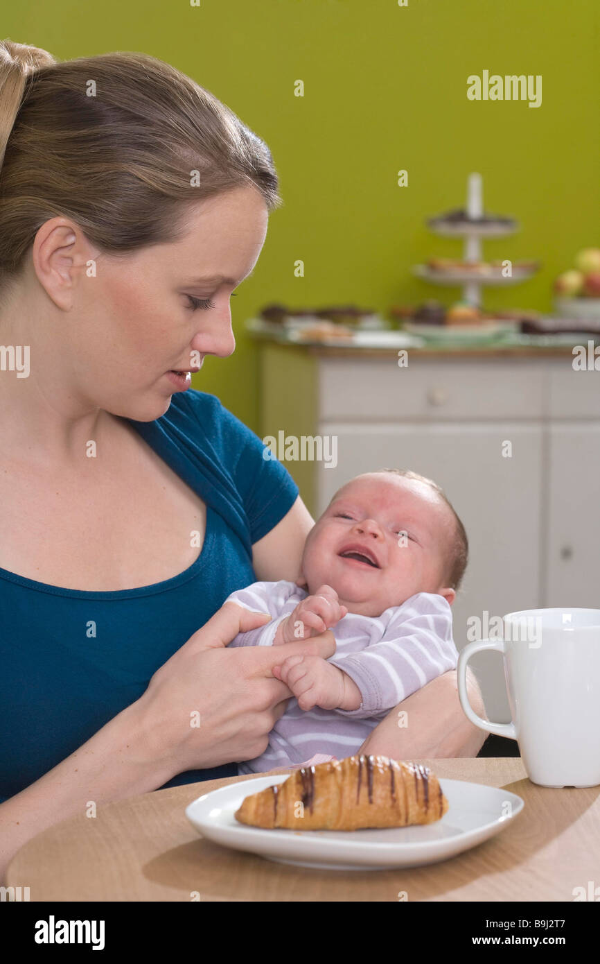Young woman caring for baby Stock Photo - Alamy