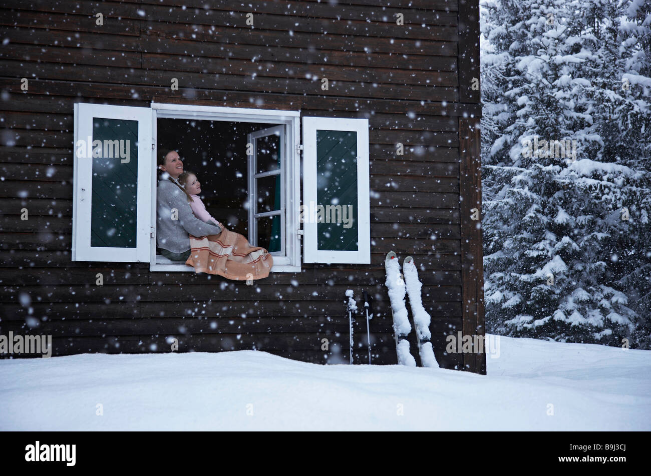 Mother and daughter sitting in window Stock Photo - Alamy
