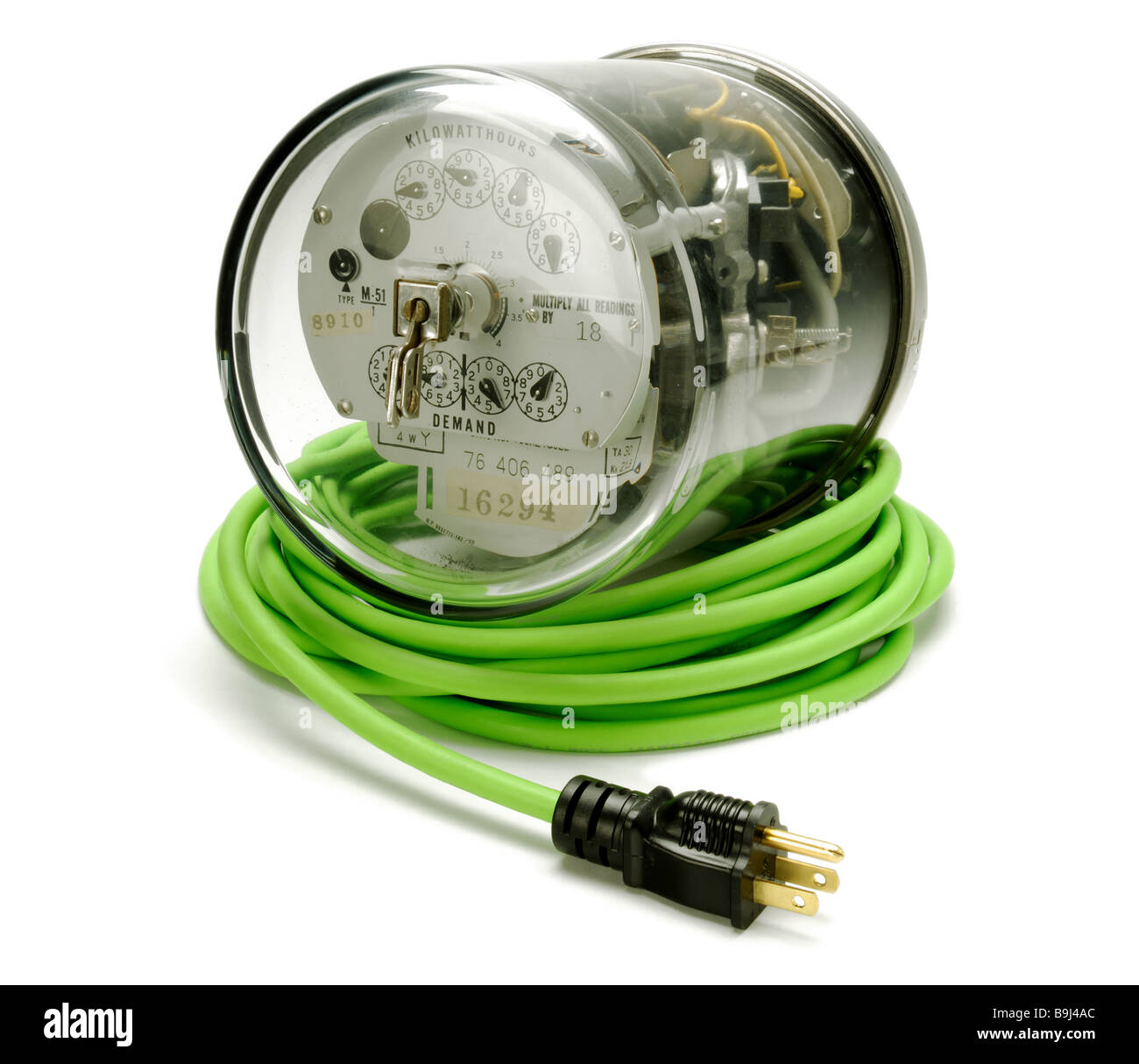 Electric power meter on a coiled green electrical extension cord and ...
