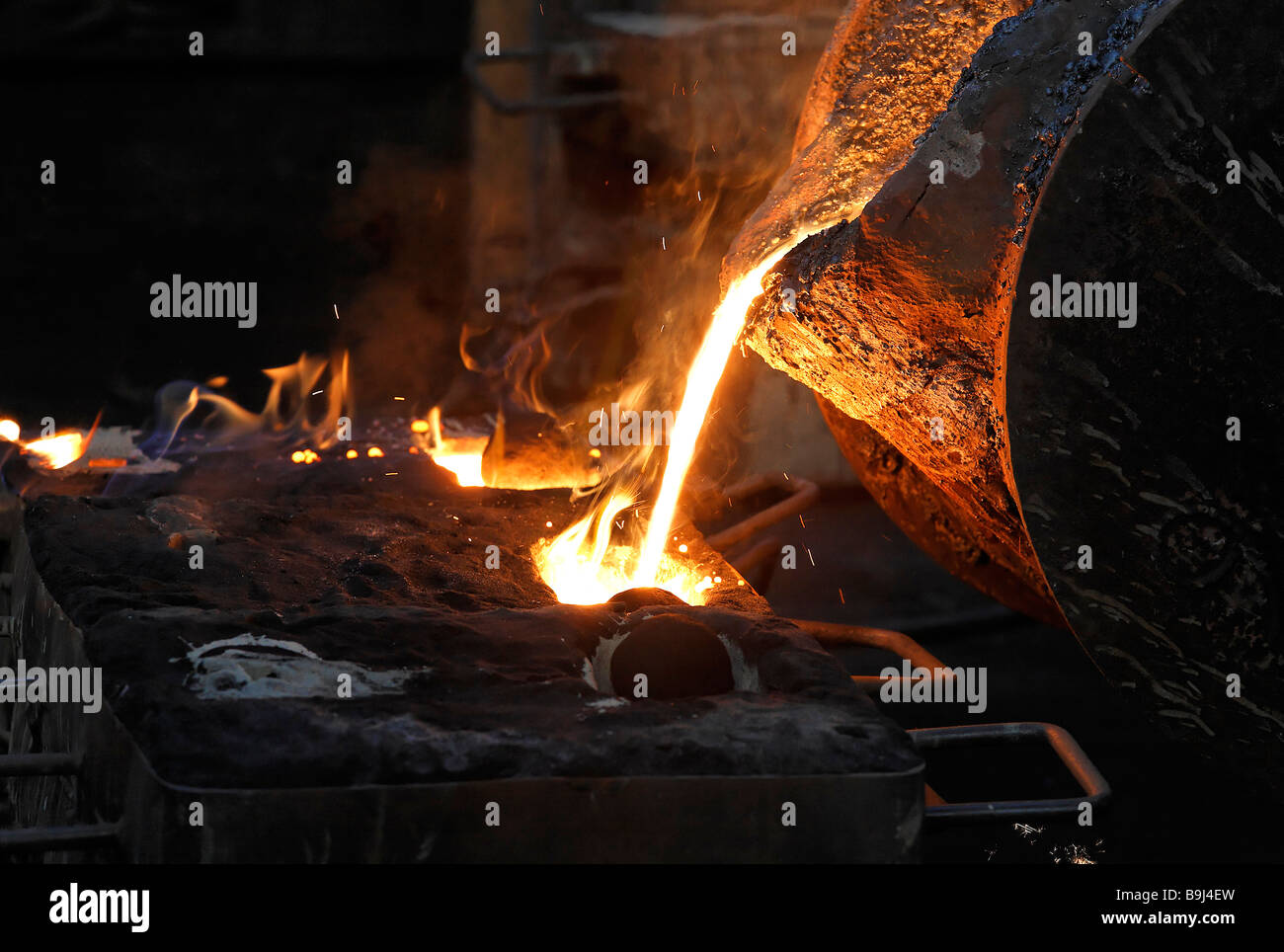 Molten iron in a crane ladle is flowing into a mold, historical iron ...