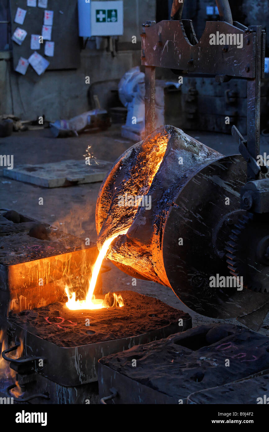 Molten iron in a crane ladle is flowing into a mold, historical iron ...