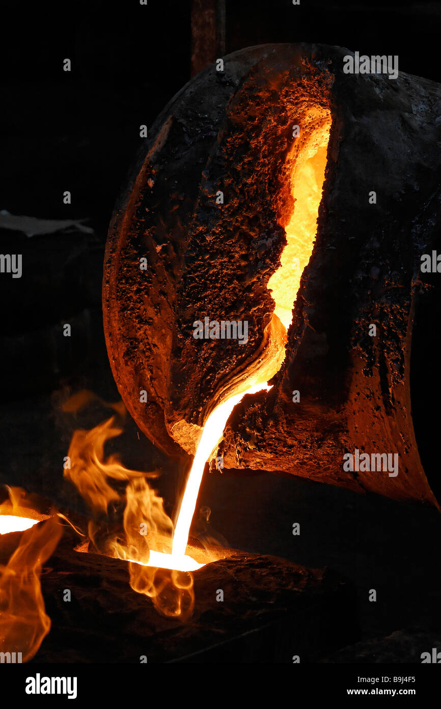 Molten iron in a crane ladle is flowing into a mold, historical iron ...