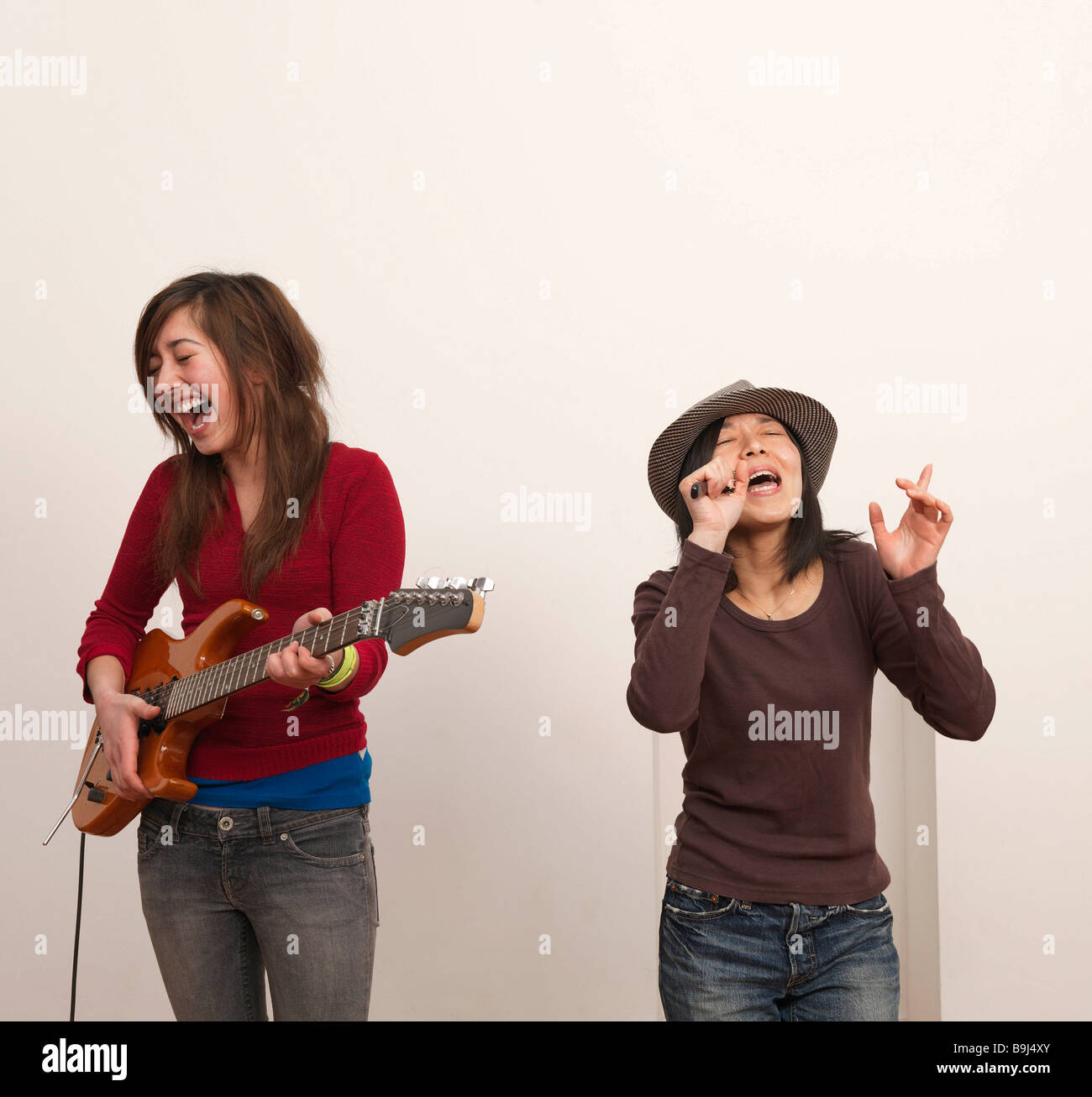 Two women singing and playing guitar Stock Photo - Alamy