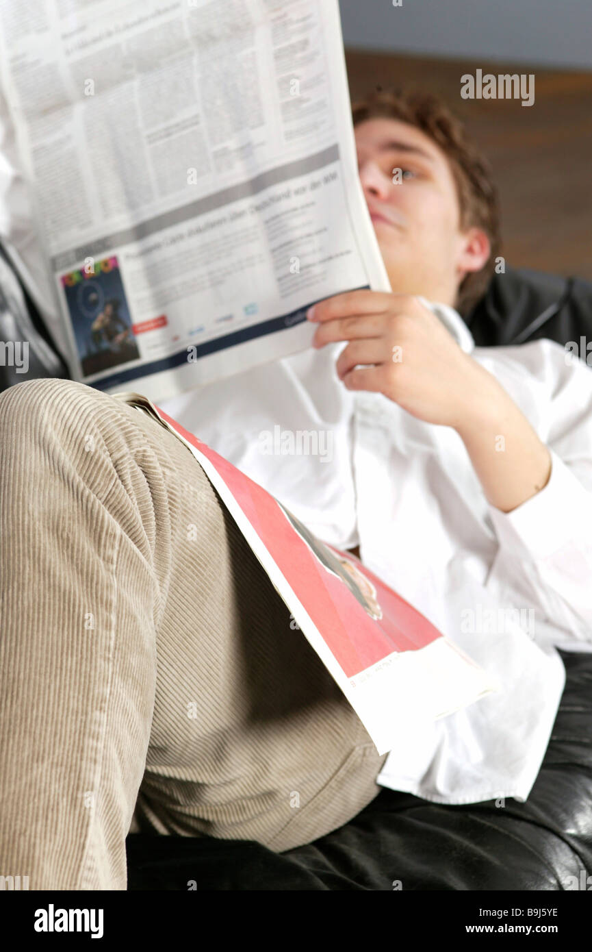 Young man reading the newspaper Stock Photo - Alamy