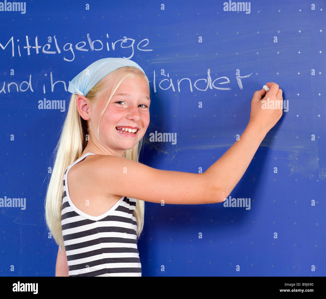 Girl, eleven years, writing with chalk on a blackboard Stock Photo - Alamy