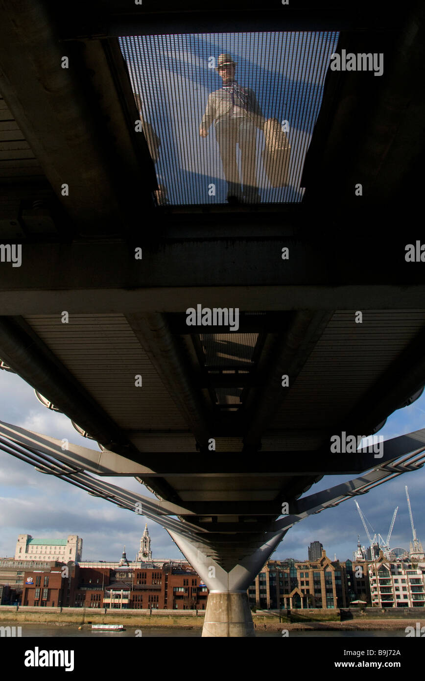 Man with case walking over the Millenium bridge, photographed fro ...