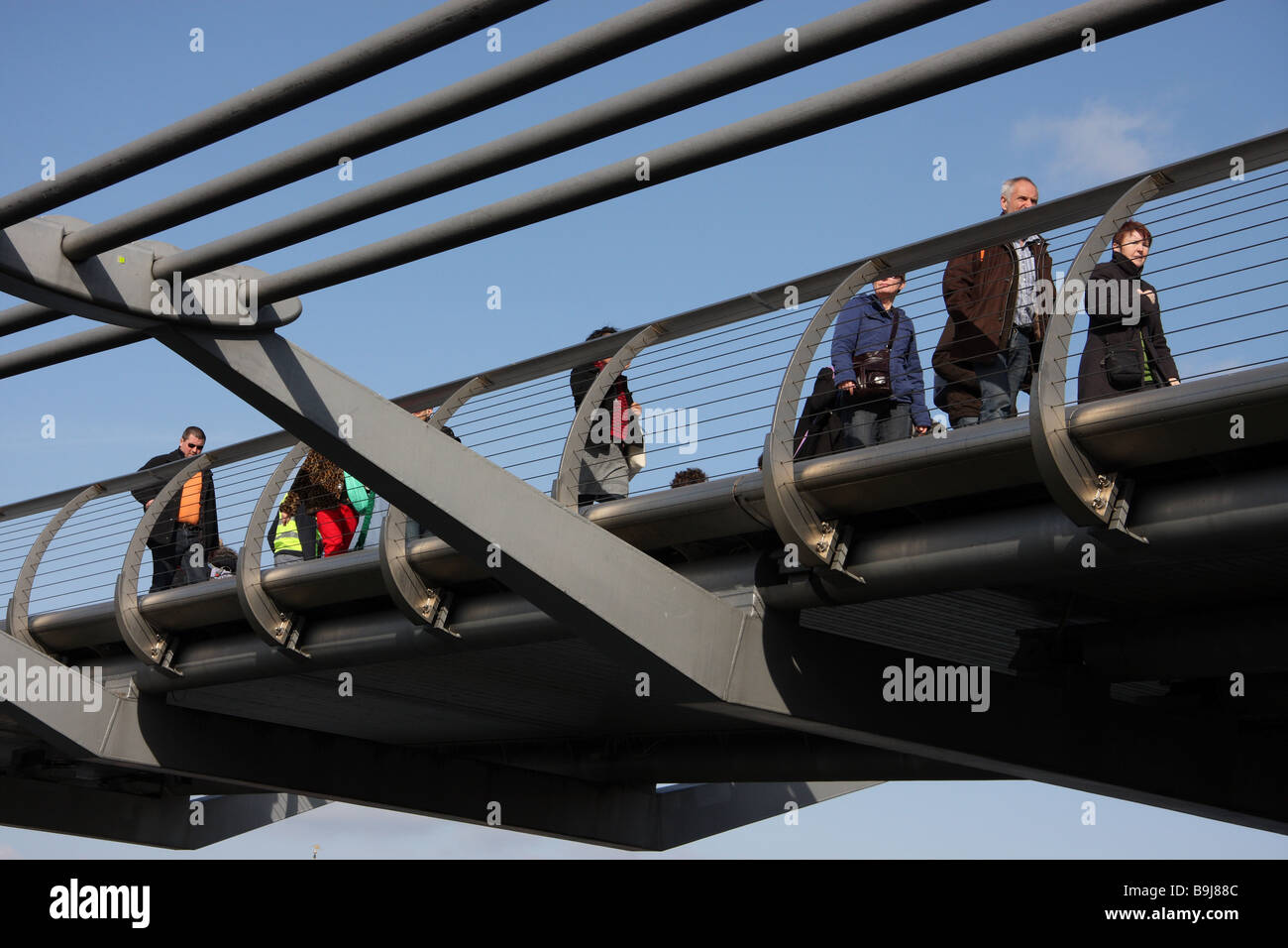 london england uk visitors walking over onto millenium bridge river ...