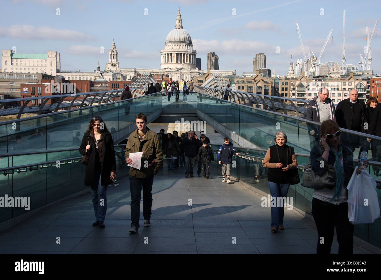 london england uk visitors walking over onto millenium bridge river ...