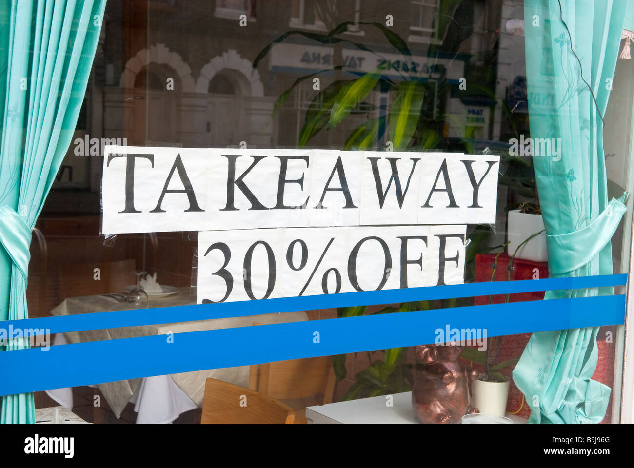 A sign on a takeaway restaurant window advertising money off Stock ...