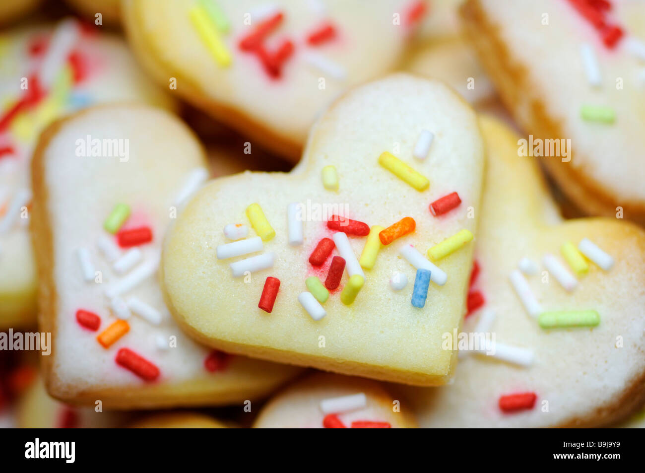 Heart-shaped short pastry biscuits with multicoloured sugar sprinkles ...