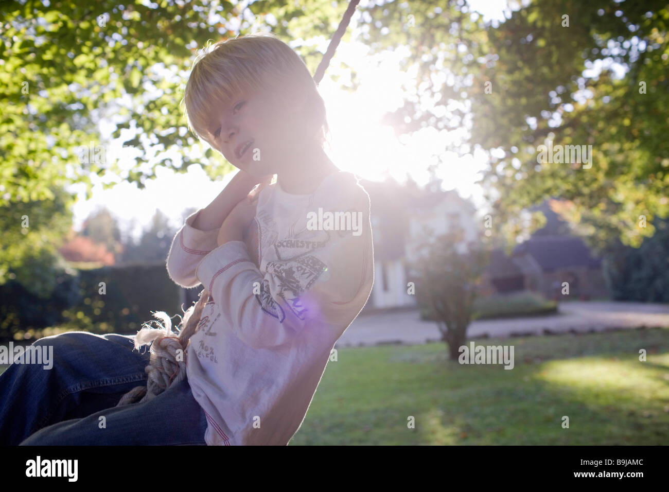 Boy on a swing Stock Photo - Alamy
