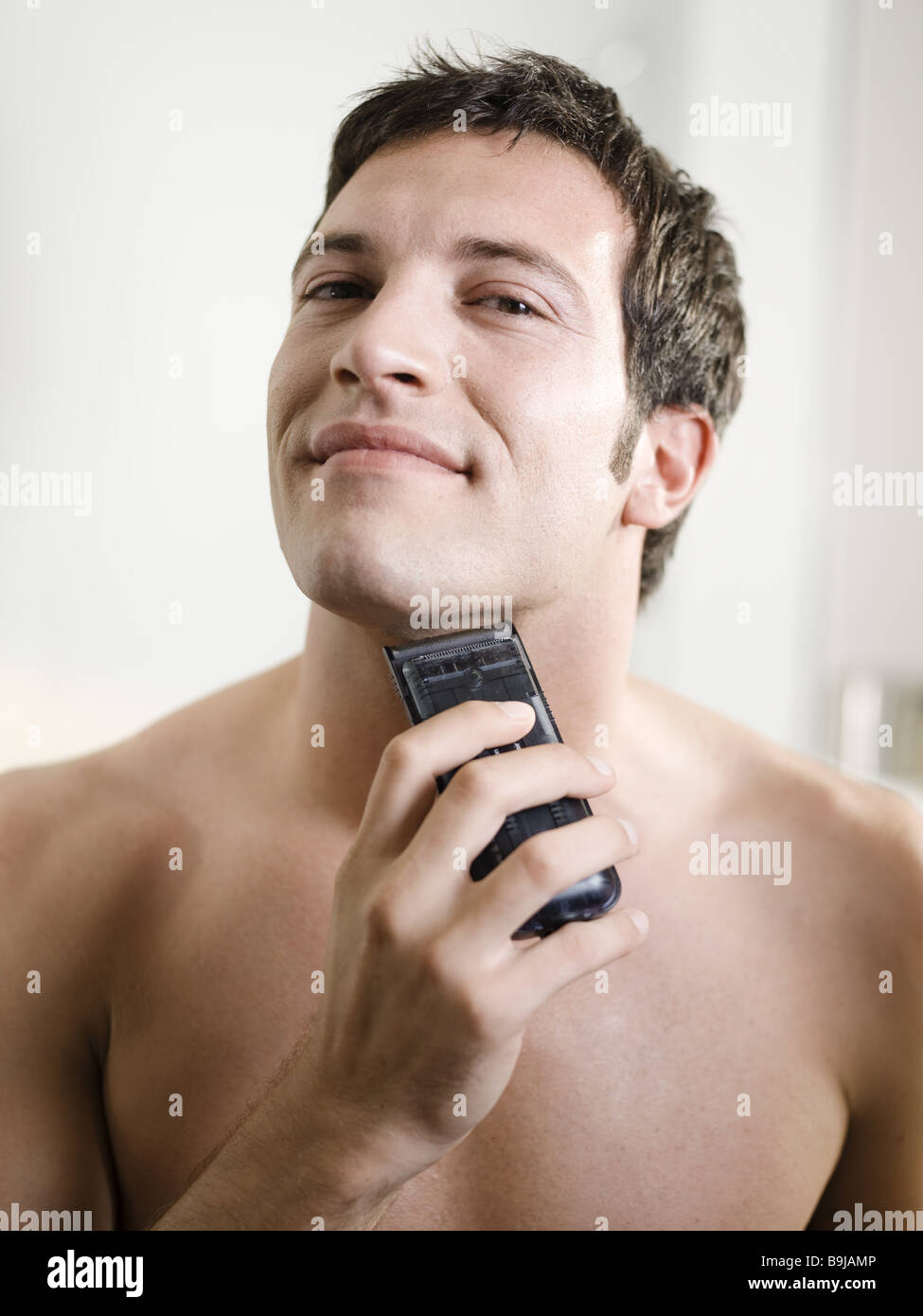 Man attractively electro-shavers shaves portrait Stock Photo - Alamy