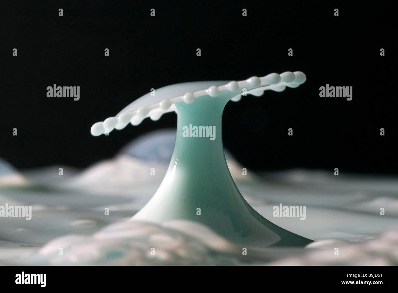 Milk dropping into blue water Stock Photo - Alamy