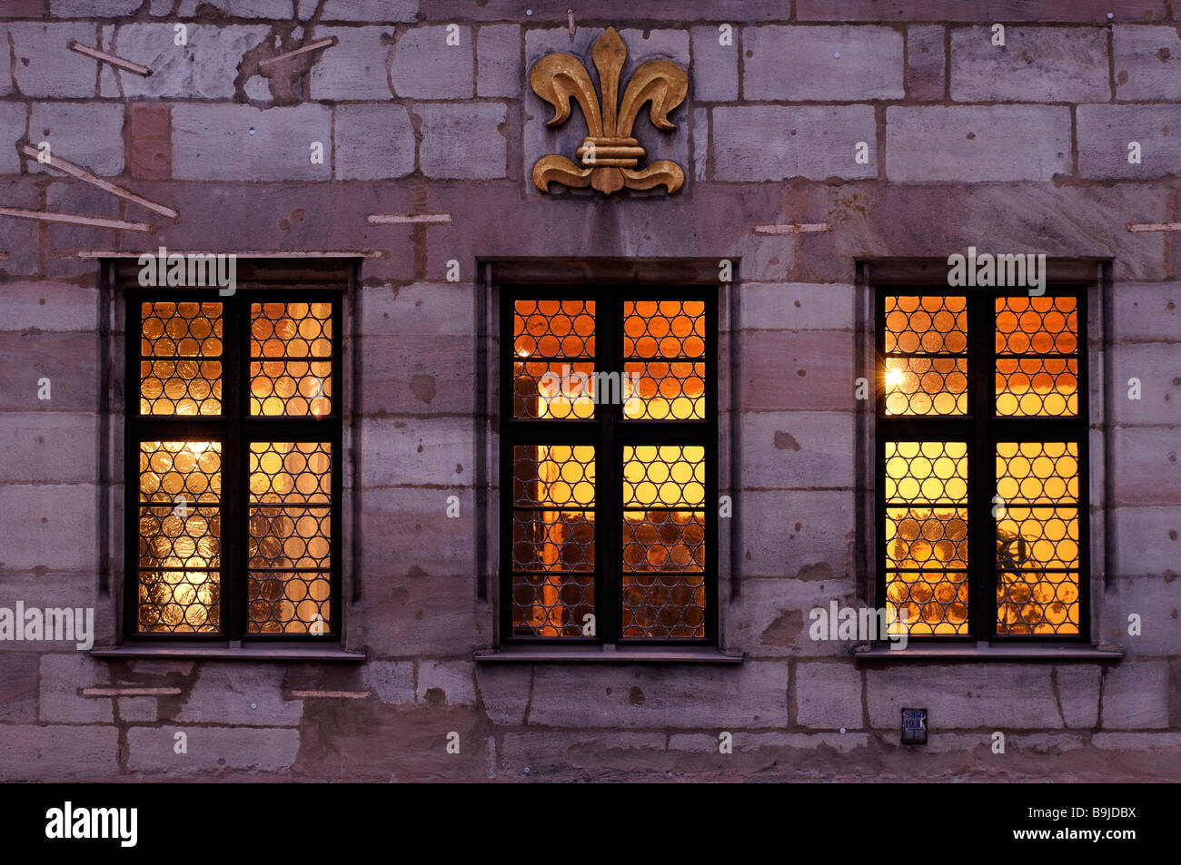 Old facade with a bourbon lily and old illuminated crown glass windows ...