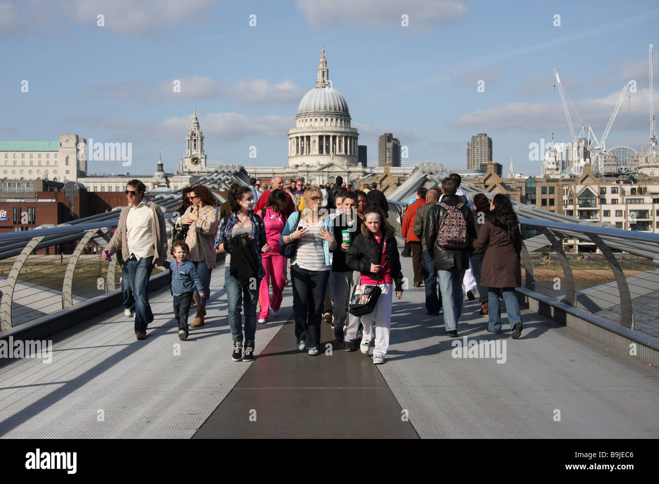 london england uk visitors walking over onto millenium bridge river ...