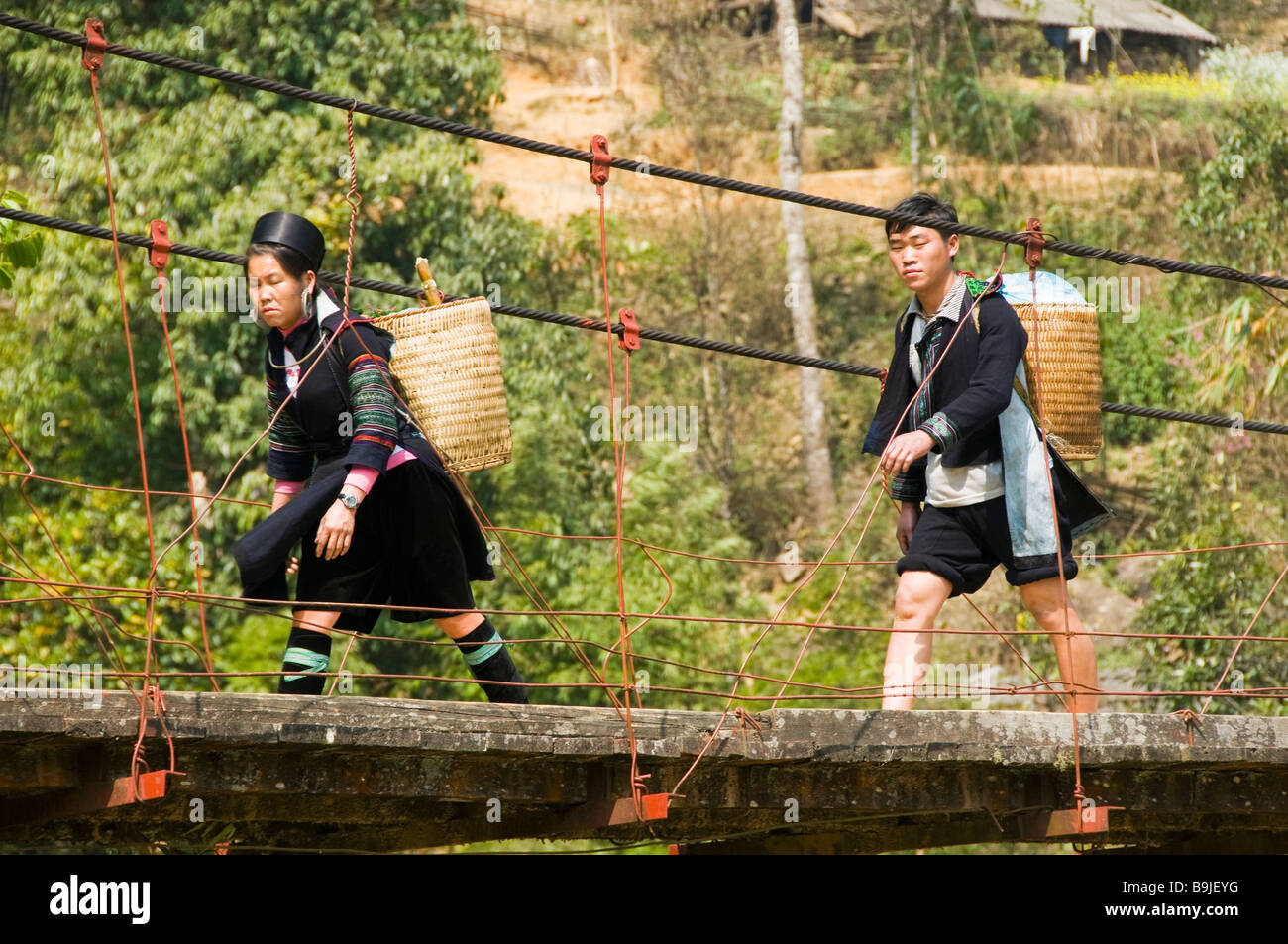 Black Hmong couple and their baskets walking near Sapa Vietnam Stock ...