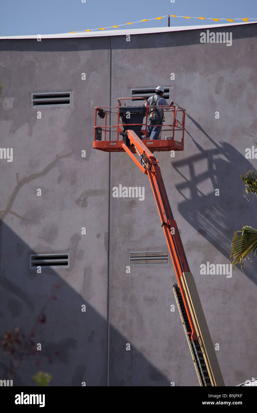 Man on a power lift working on a pre fab concrete building Stock Photo ...