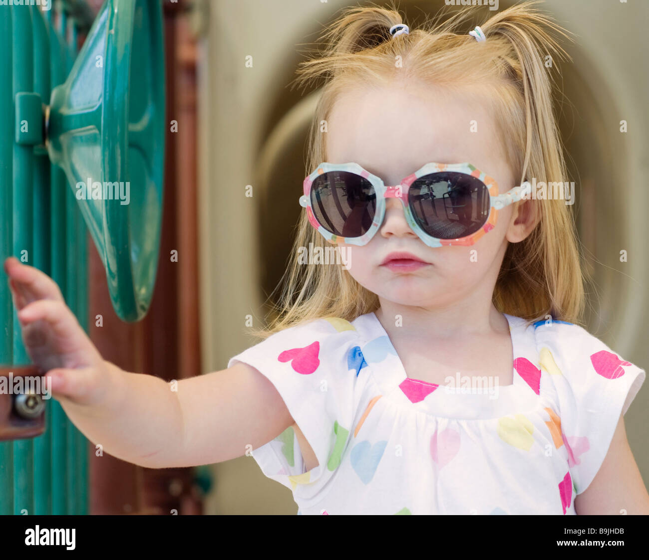 Adorable little toddler girl playing outside in the summer sunshine ...
