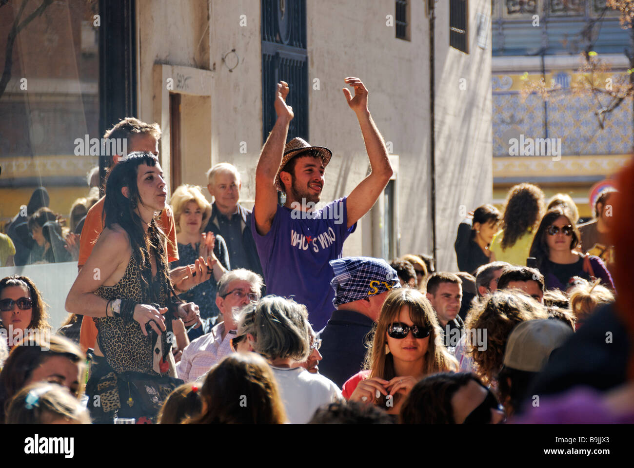 Young people listening to a band busking during Las Fallas festival in ...