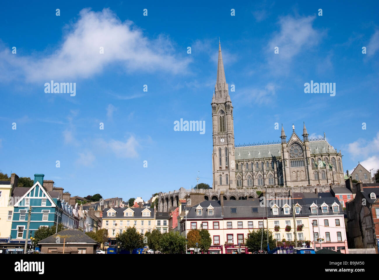 Cobh waterfront and shops with St. Colman's Cathedral in the background ...