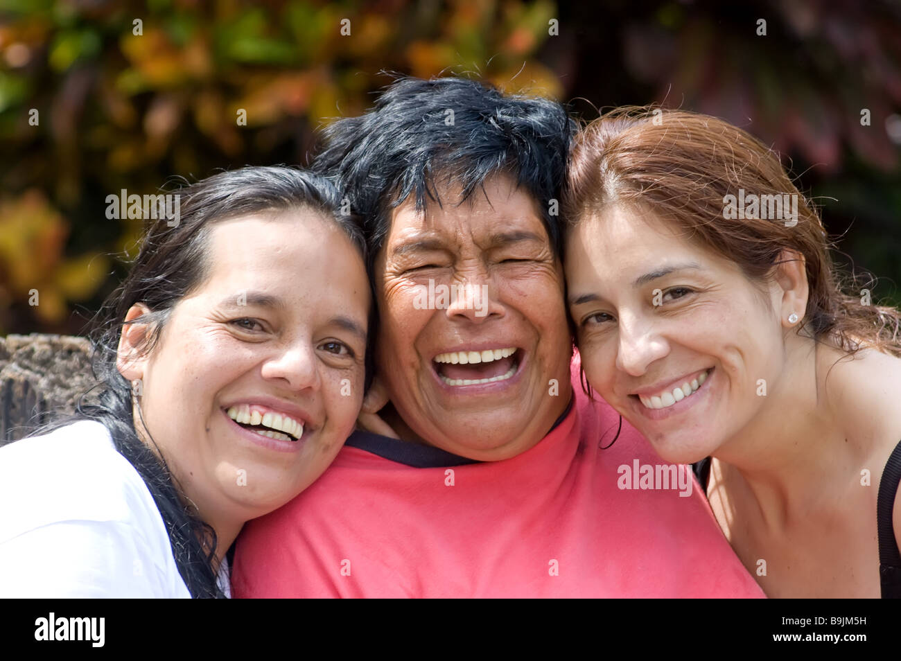 A laughing mother flanked by her two middle aged daughters Stock Photo ...