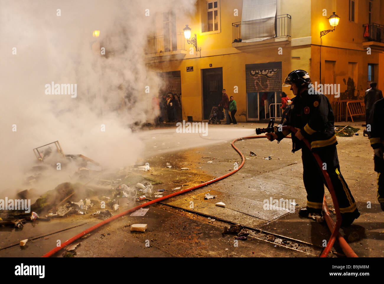 Fireman dowsing the flames of a burning Ninot sculpture La Crema during ...